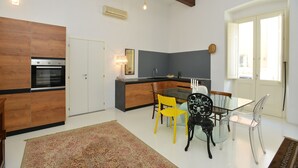 Uma cozinha moderna com armários de madeira, uma mesa de jantar de vidro e duas cadeiras.
