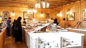 Disposição de buffet com várias estações de serviço e uma variedade de alimentos.