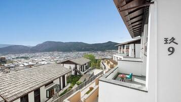Edifício residencial com vista para a paisagem urbana e montanhas ao fundo.