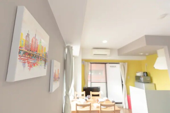 Um interior moderno com área de jantar, parede amarela e ar condicionado.