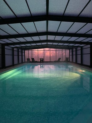 Piscina interior, guarda-sóis, espreguiçadeiras