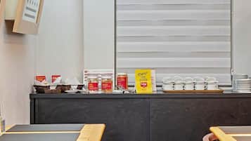 Uma mesa de pequeno-almoço com balcão, uma janela com persianas e um sinal a indicar opções sem glúten.