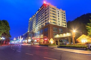 Um hotel de vários andares com entrada imponente e fachada bem iluminada.
