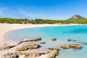 Perto da praia, areia branca, espreguiçadeiras, guarda-sóis 