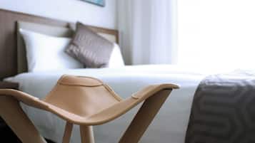 Quarto de hotel com uma cama, cabeceira e uma cadeira.