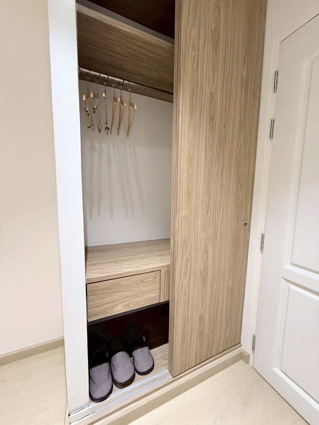 Um closet amplo com prateleiras de madeira e sapateira.