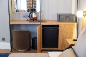 Uma cozinha compacta equipada com cafeteira, chaleira e mini-geladeira.