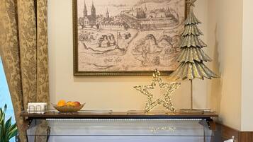 Disposição de buffet com diversos alimentos, um mapa histórico emoldurado, um pinheiro de Natal decorativo e um enfeite de estrela em um suporte.