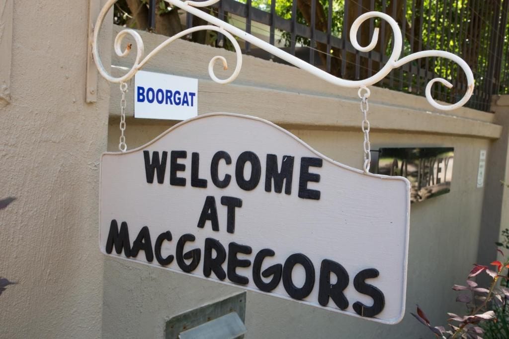 Uma placa de boas-vindas em Macgregors, com uma placa menor acima escrita 'BOORGAT'.