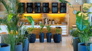 Cozinha moderna com bancada de madeira, eletrodomésticos pretos e plantas em vasos.