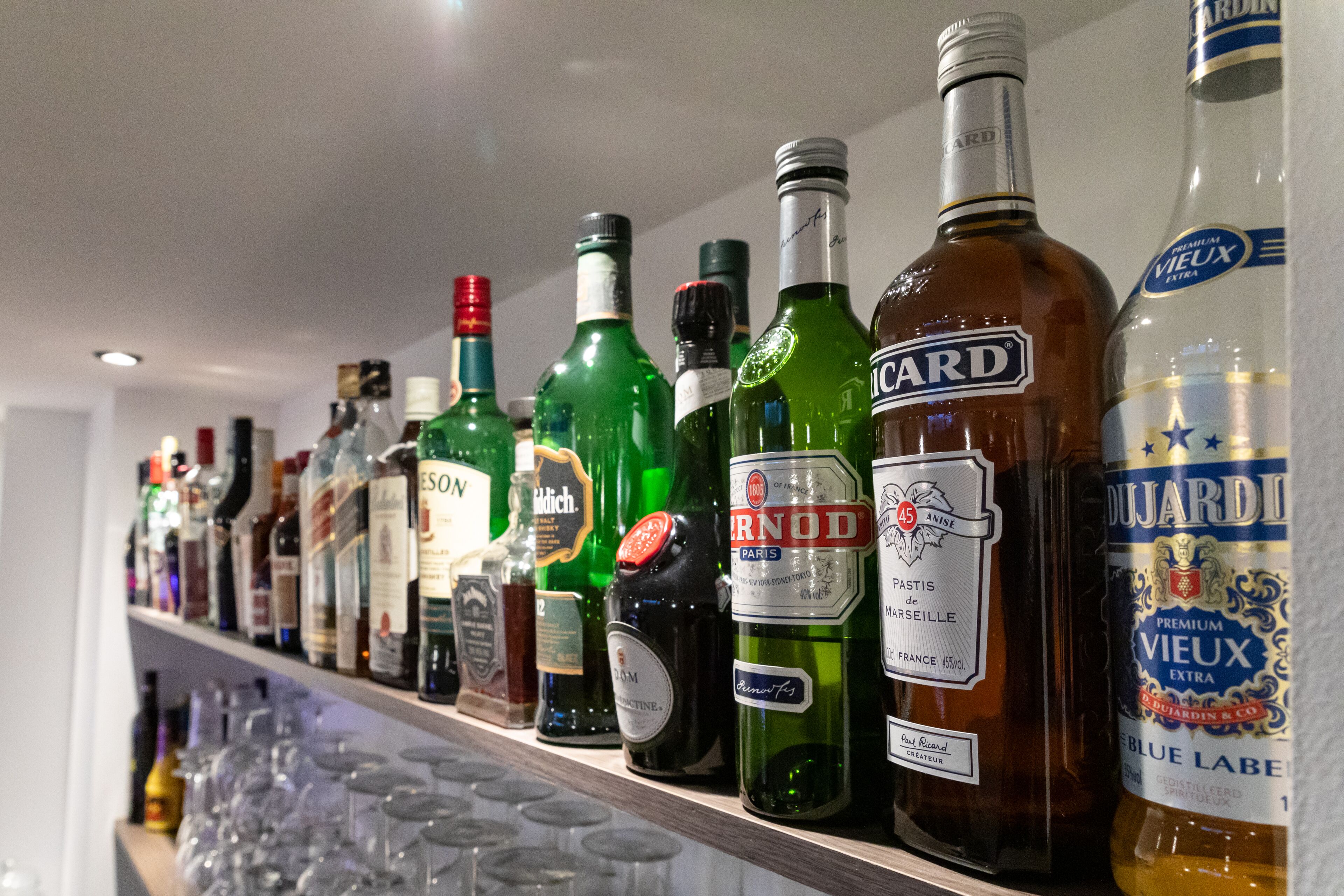 Diversas garrafas de bebidas alcoólicas numa prateleira.