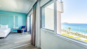 Quarto de hotel moderno com uma janela grande, uma cama, uma cadeira e uma pequena mesa.