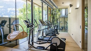 Uma academia moderna com equipamentos de ginástica, janelas amplas e vista para o exterior.