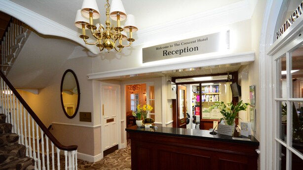 Uma área de recepção com uma placa que diz "Welcome to The Crescent Hotel Reception".