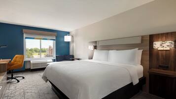 Quarto de hotel moderno com uma cama grande, uma escrivaninha e uma cadeira.