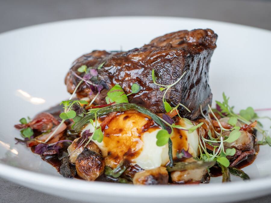 Um prato de comida com carne, legumes e molho.