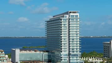Um hotel alto com piscina e acesso à praia, com vista para o oceano.