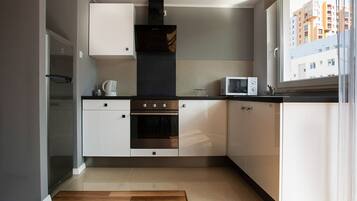 Apartamento Comfort, vista para o jardim | Kitchenette privada | Um frigorífico/congelador grande, um micro-ondas, uma placa de cozinha