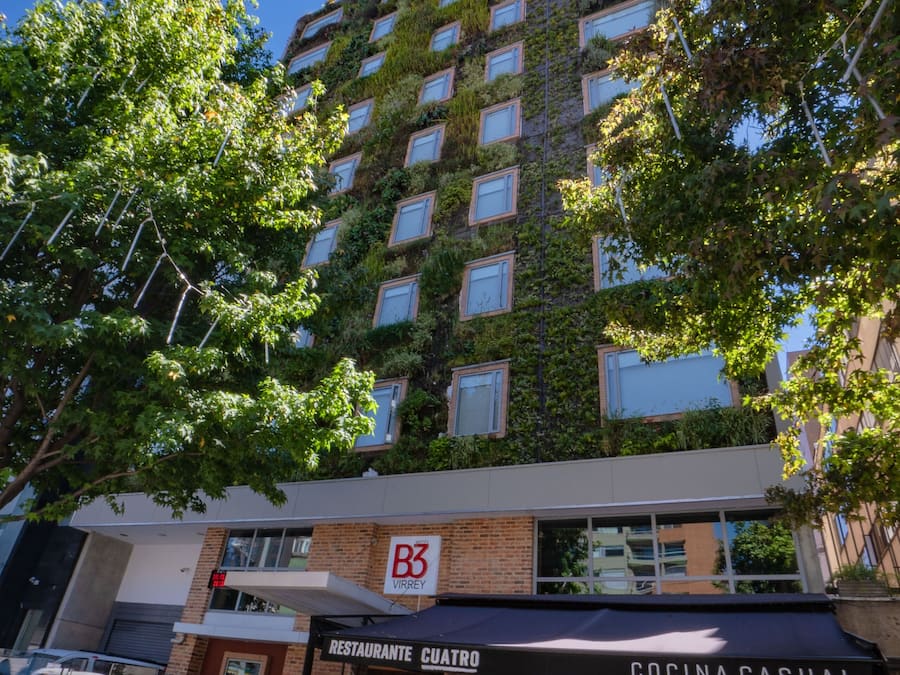 Um edifício moderno com um restaurante chamado 'Restaurante Catro' e 'Cocina Casual' no andar térreo.