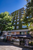 Um edifício moderno com um restaurante chamado 'Restaurante Catro' e 'Cocina Casual' no andar térreo.