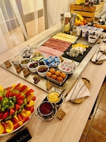 Um buffet de café da manhã com diversos alimentos e acompanhamentos.