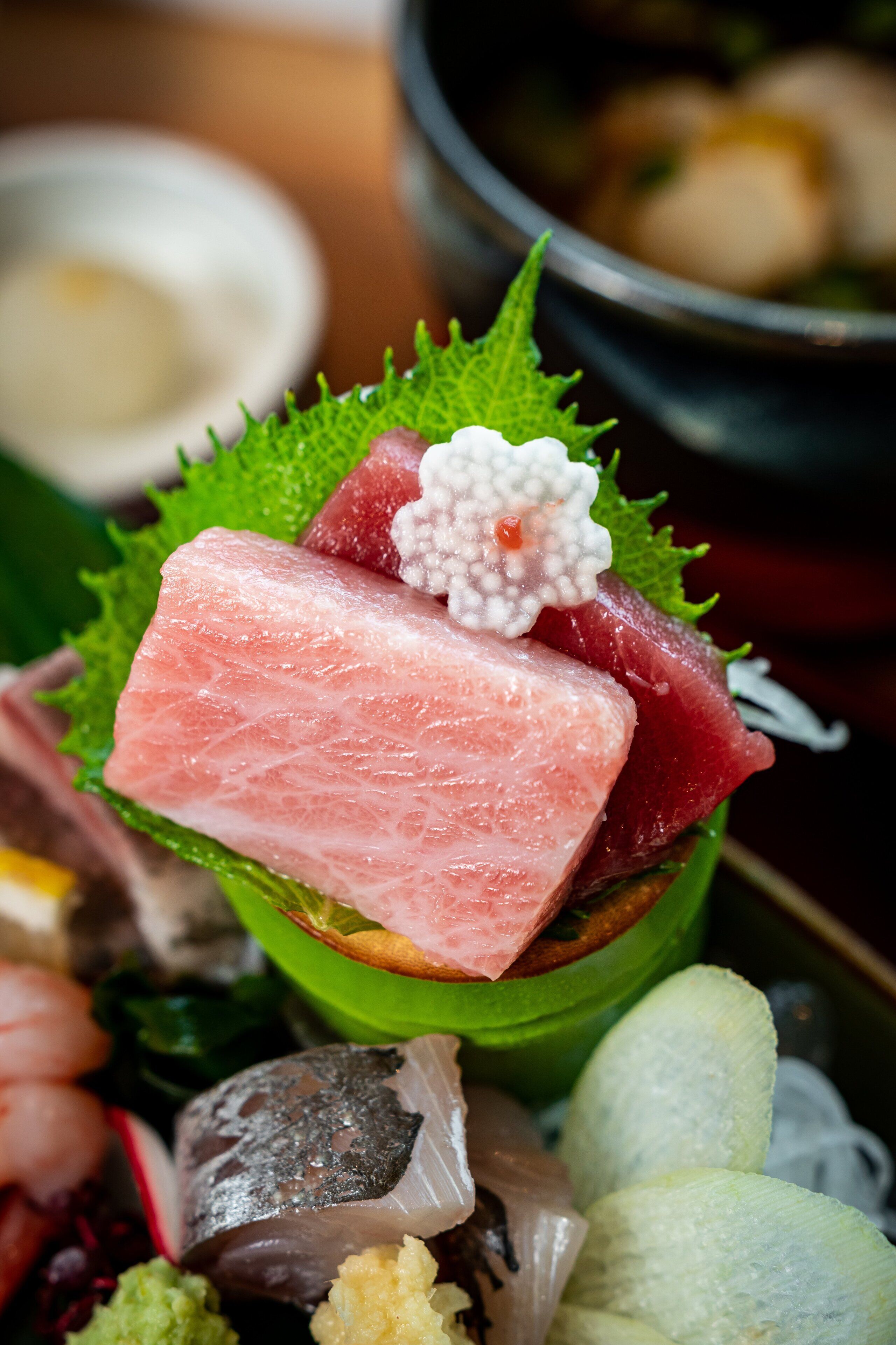 Uma bandeja de sushi com diversos tipos de peixe e guarnições.