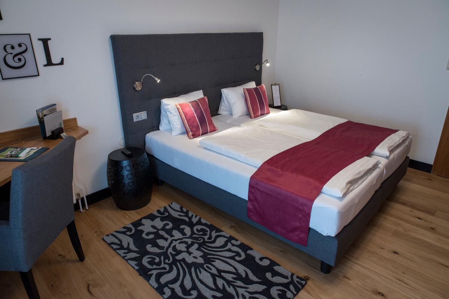 Quarto moderno com uma cama grande, uma escrivaninha e uma cadeira.