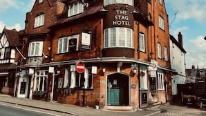 Um edifício de tijolos tradicional com uma placa que diz 'The Stag Hotel'.