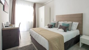 Quarto moderno com uma cama grande, uma escrivaninha e uma cadeira.