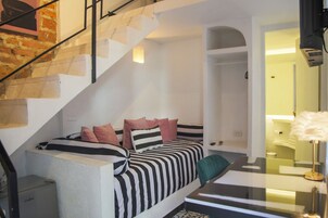 Quarto moderno com sofá, mesa de centro e escada.