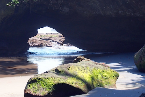 Perto da praia, areia preta, guarda-sóis