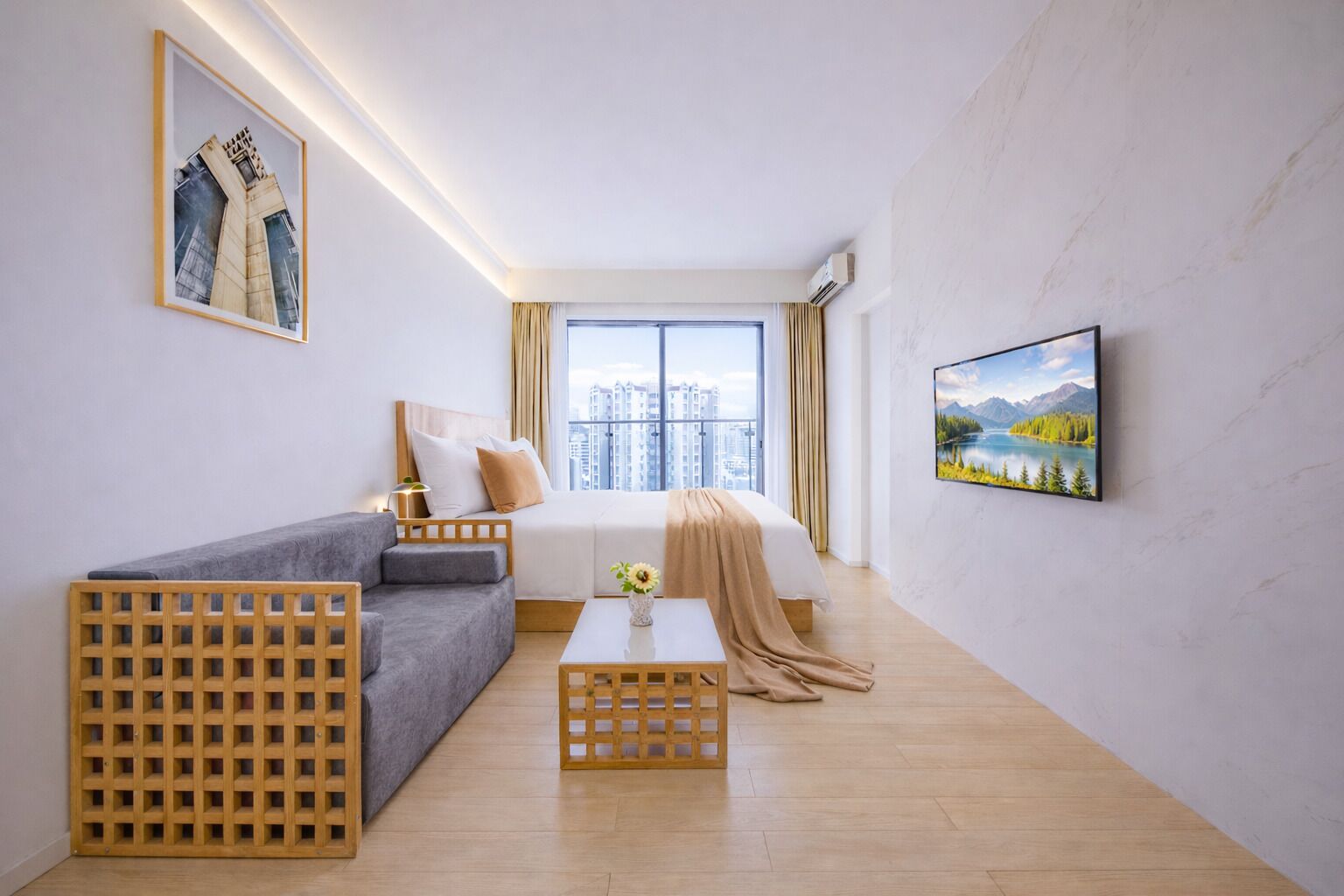 Quarto de hotel moderno com cama, sofá, piso de madeira, televisão e vista para a cidade.