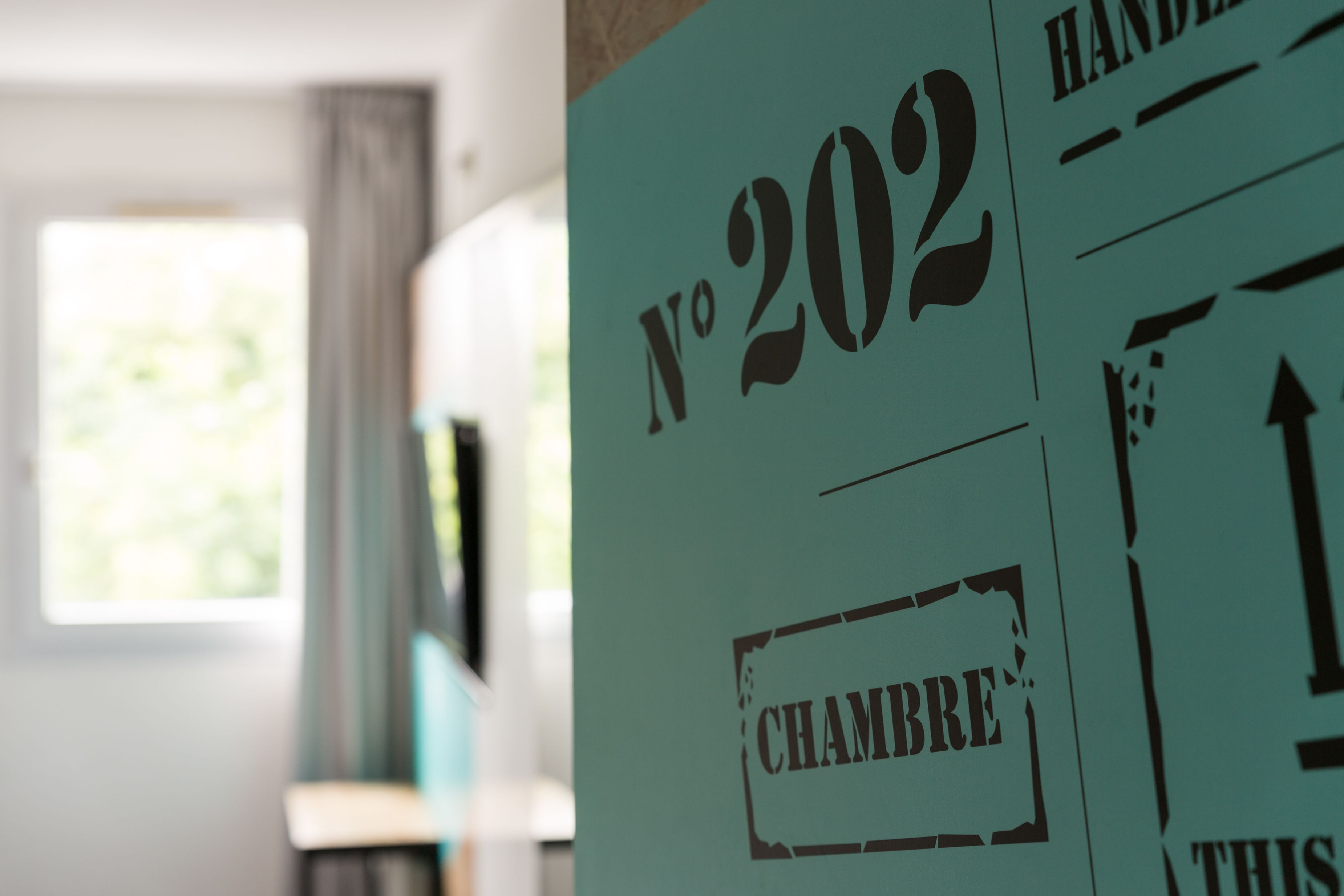 Um quarto com uma placa indicando o número 202 e uma etiqueta para o banheiro.