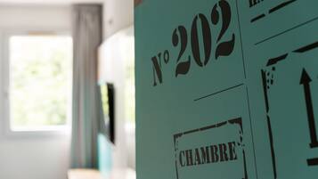 Um quarto com uma placa indicando o número 202 e uma etiqueta para o banheiro.