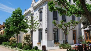 Um edifício histórico com arquitetura clássica, caracterizado por janelas simétricas e elementos decorativos.