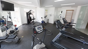 Uma academia com esteiras, elípticos e equipamentos de musculação.