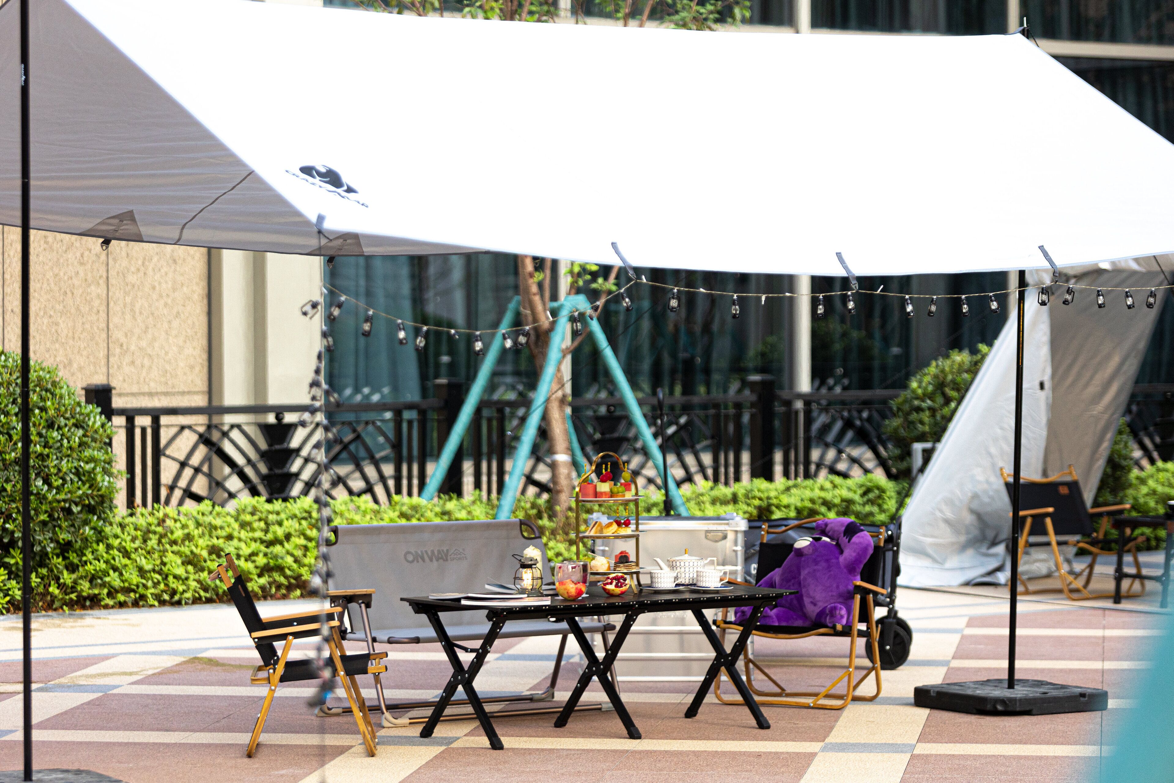 Uma área de estar externa com mesa, cadeiras e uma tenda.