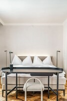 Quarto moderno com uma cama, uma mesinha e uma cadeira.