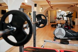 Uma academia com equipamentos de musculação, esteiras e bicicletas ergométricas.