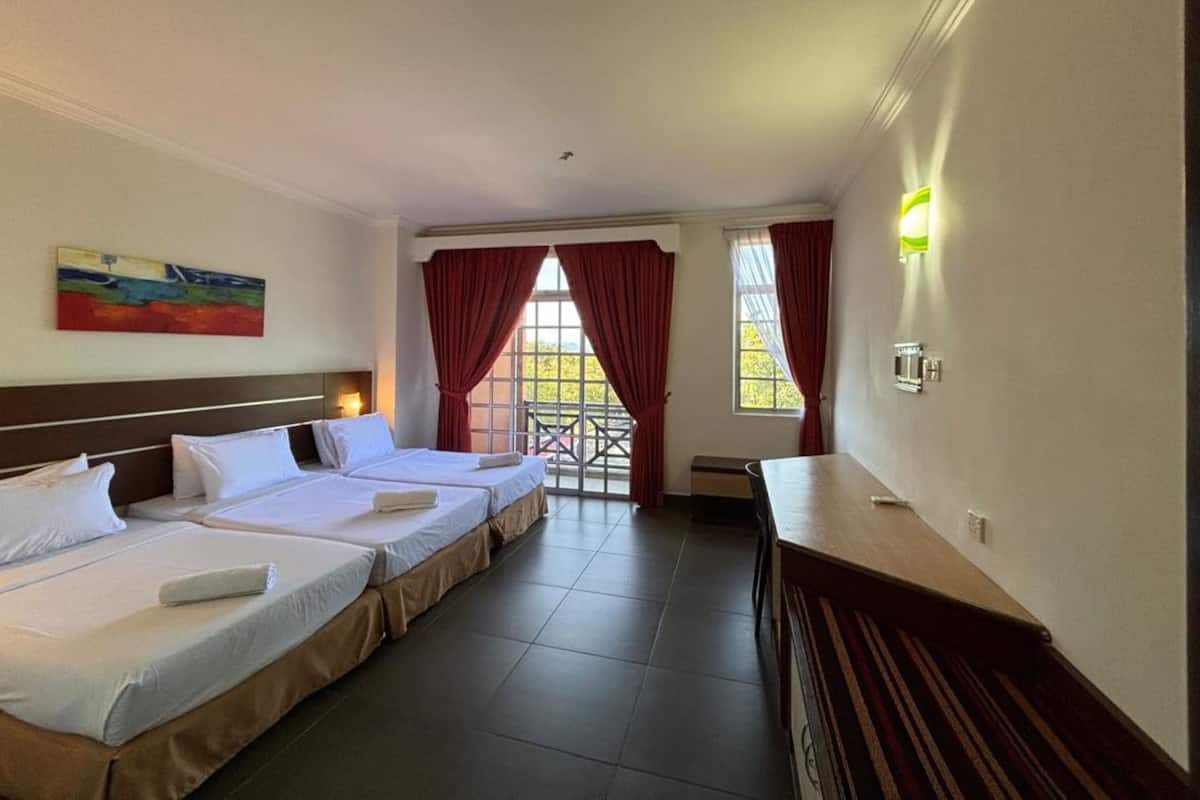 Quarto de hotel com duas camas, um quadro na parede e uma varanda com cortinas vermelhas.