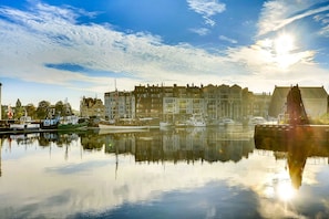 Um porto tranquilo com barcos e edifícios refletidos na água.