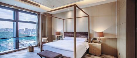 Quarto de hotel moderno com uma cama grande, vista da cidade e uma varanda.