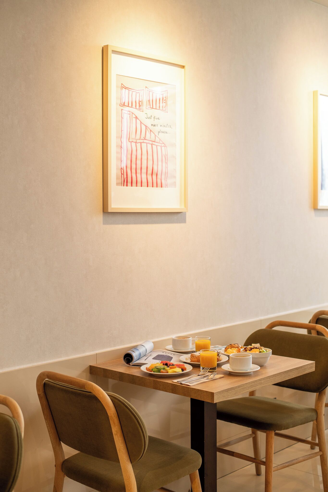 Uma área de refeições com uma mesa posta para o café da manhã, incluindo pratos de comida, xícaras e um menu enrolado.