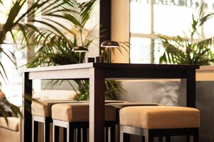 Uma área de bar moderna com dois bancos altos e uma luminária de bar.
