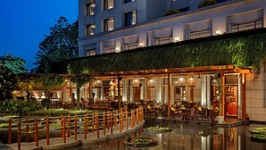 Um hotel com jardim no terraço, área de refeições ao ar livre e piscina refletora.