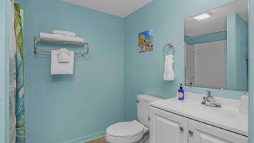 Casa de banho com sanita, lavatório e porta-toalhas.