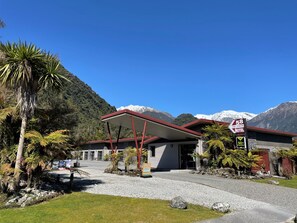 Um motel com teto vermelho, situado numa região montanhosa sob um céu limpo.