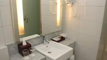 Uma casa de banho moderna com uma pia branca, um espelho e um porta-toalhas.