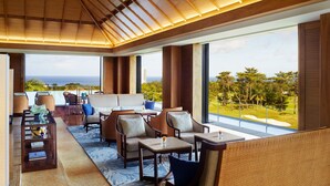 Uma área de estar moderna com vista para o oceano e para o campo de golfe.