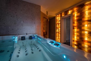 Uma área de spa moderna com hidromassagem, painéis de parede de madeira e uma porta que dá para outro espaço.